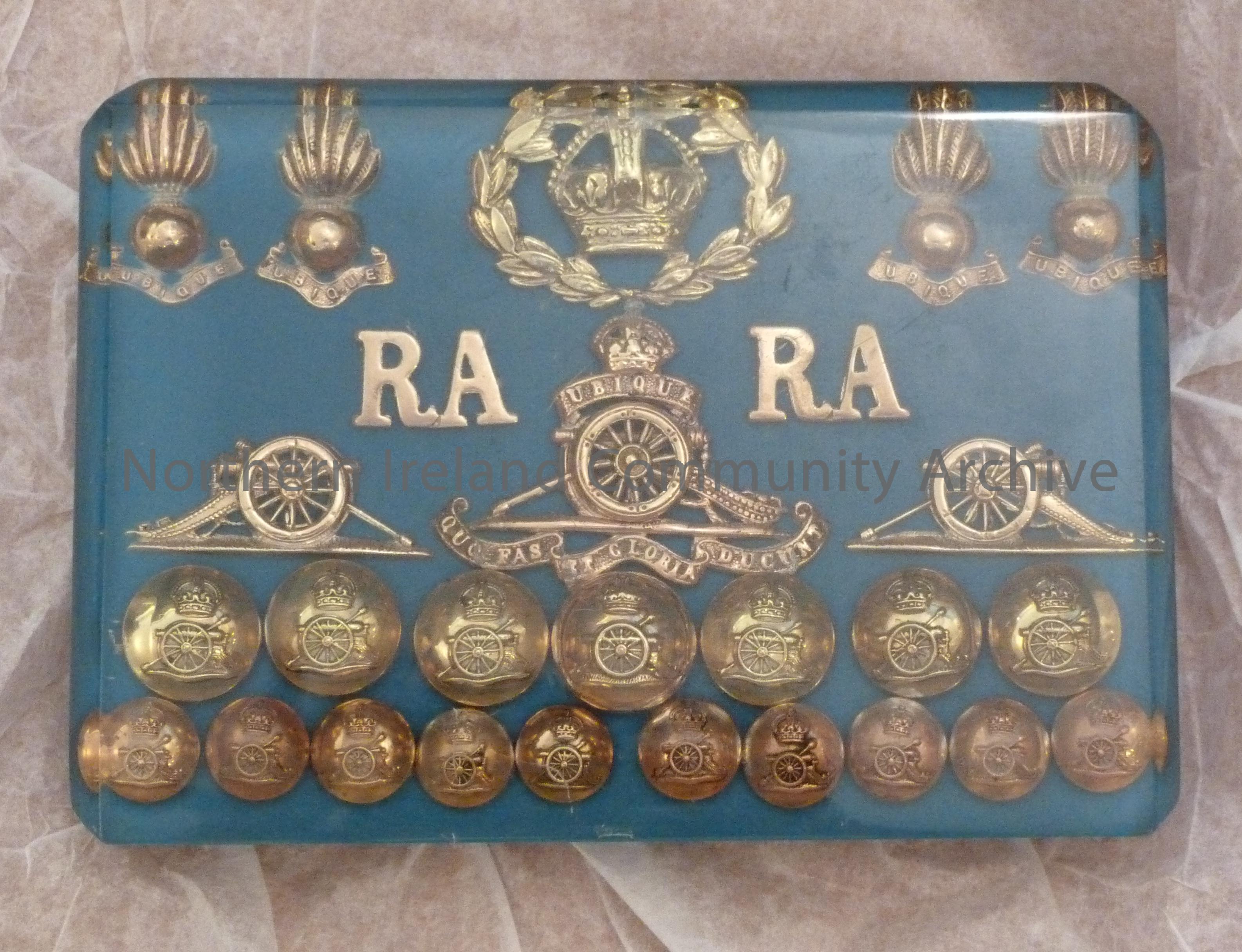 Collection of Royal Artillery buttons and badges encased in a clear ...
