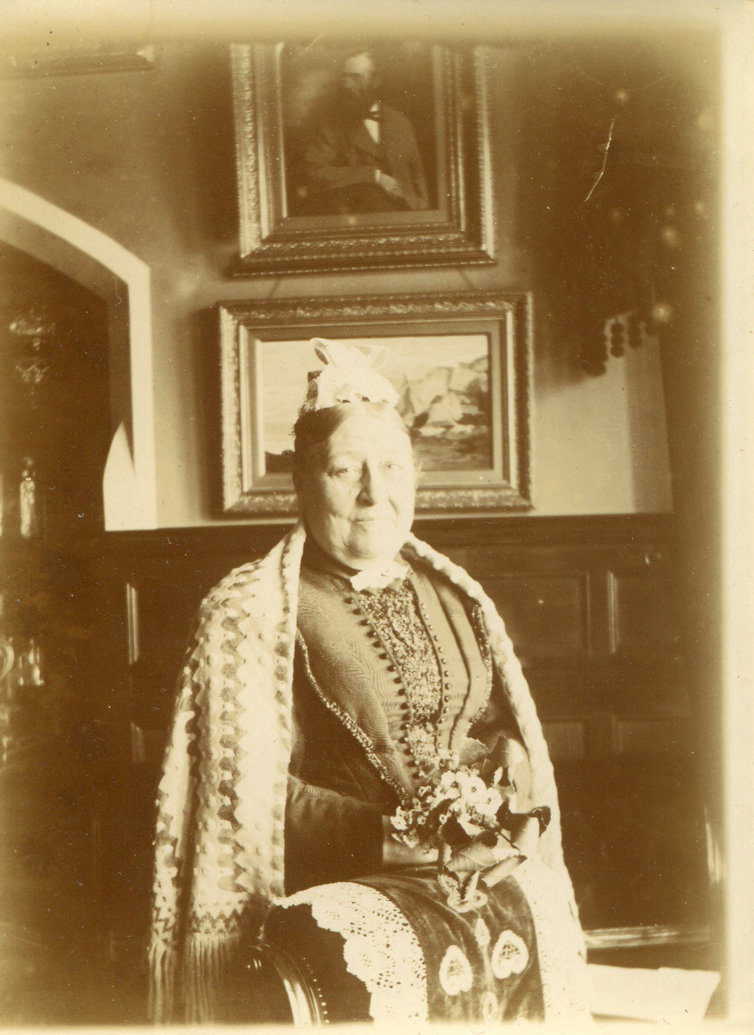 Black and white photograph of a woman standing behind a chair with a ...