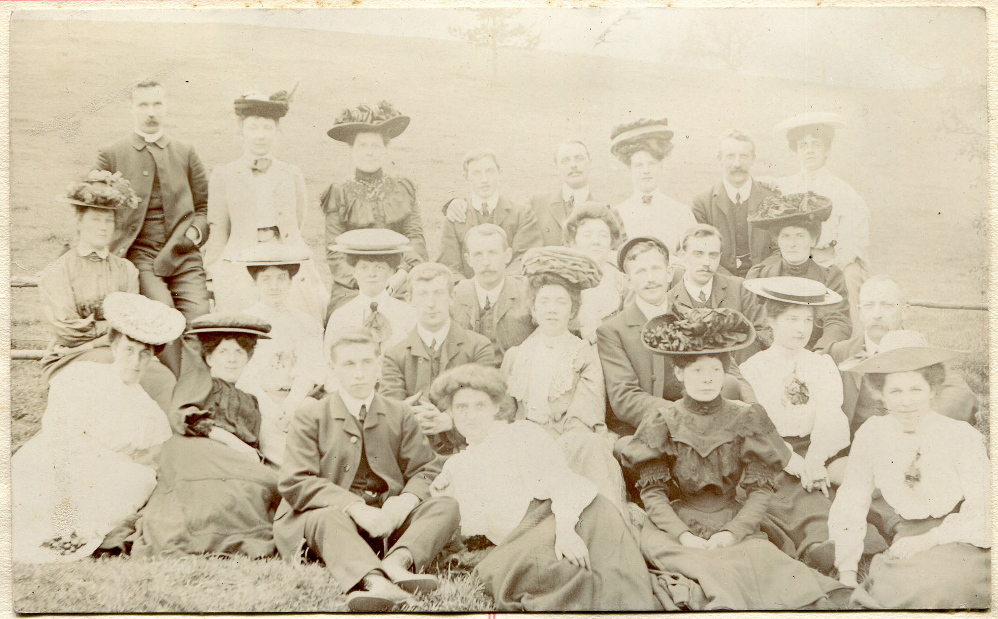 Black and white photograph of a large group of men and women sitting ...